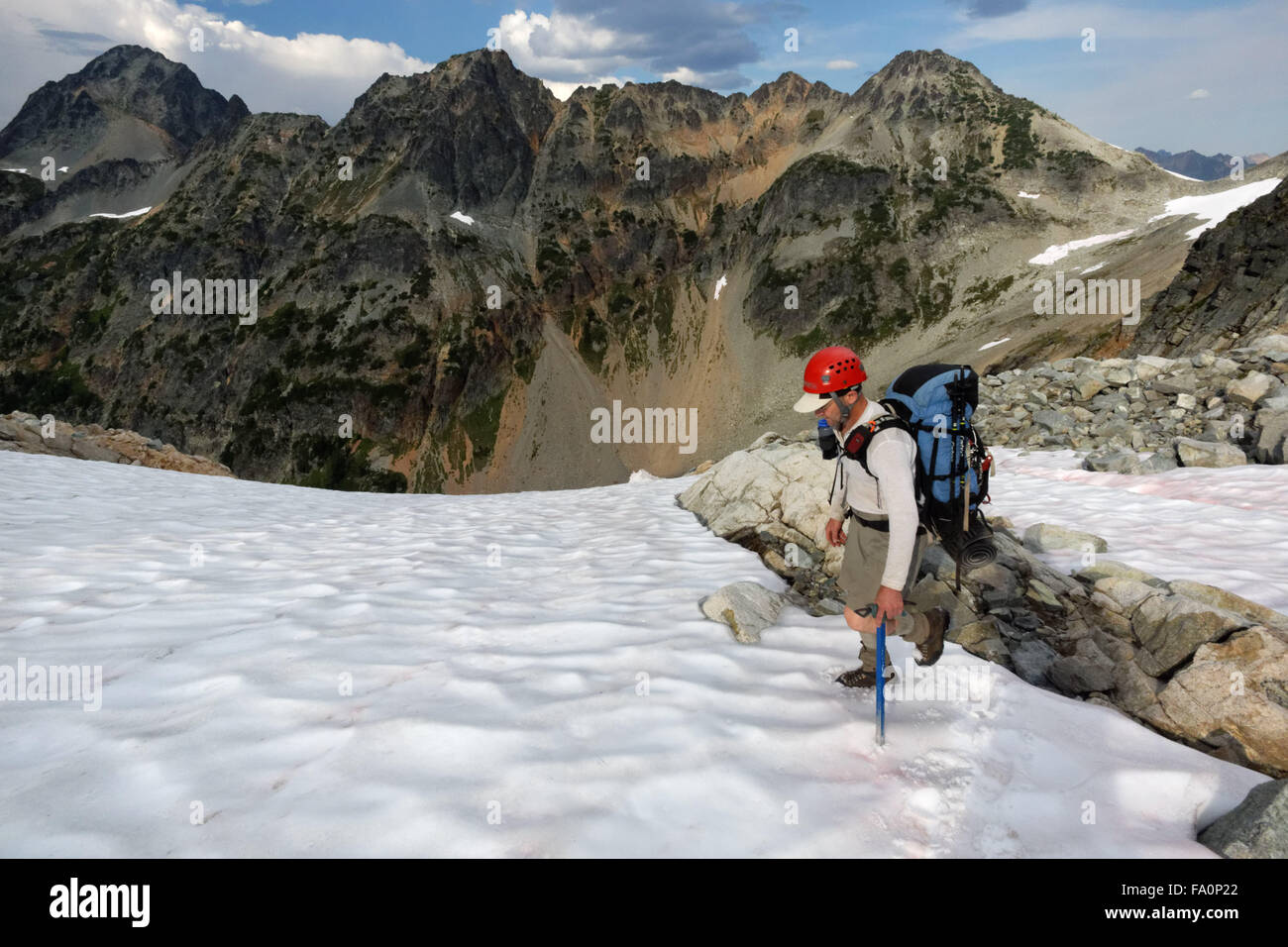 Man hiking on snow field above Fisher River Basin near Fisher Lakes ...
