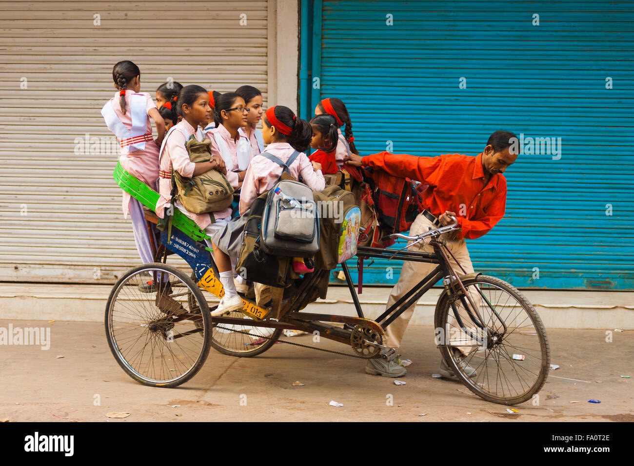 Young girls crammed into an overloaded private cycle rickshaw riding ...