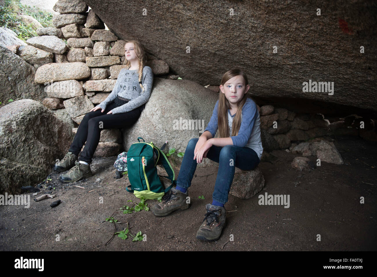 Two young girls taking shelter in a cave in Sardinia Stock Photo - Alamy