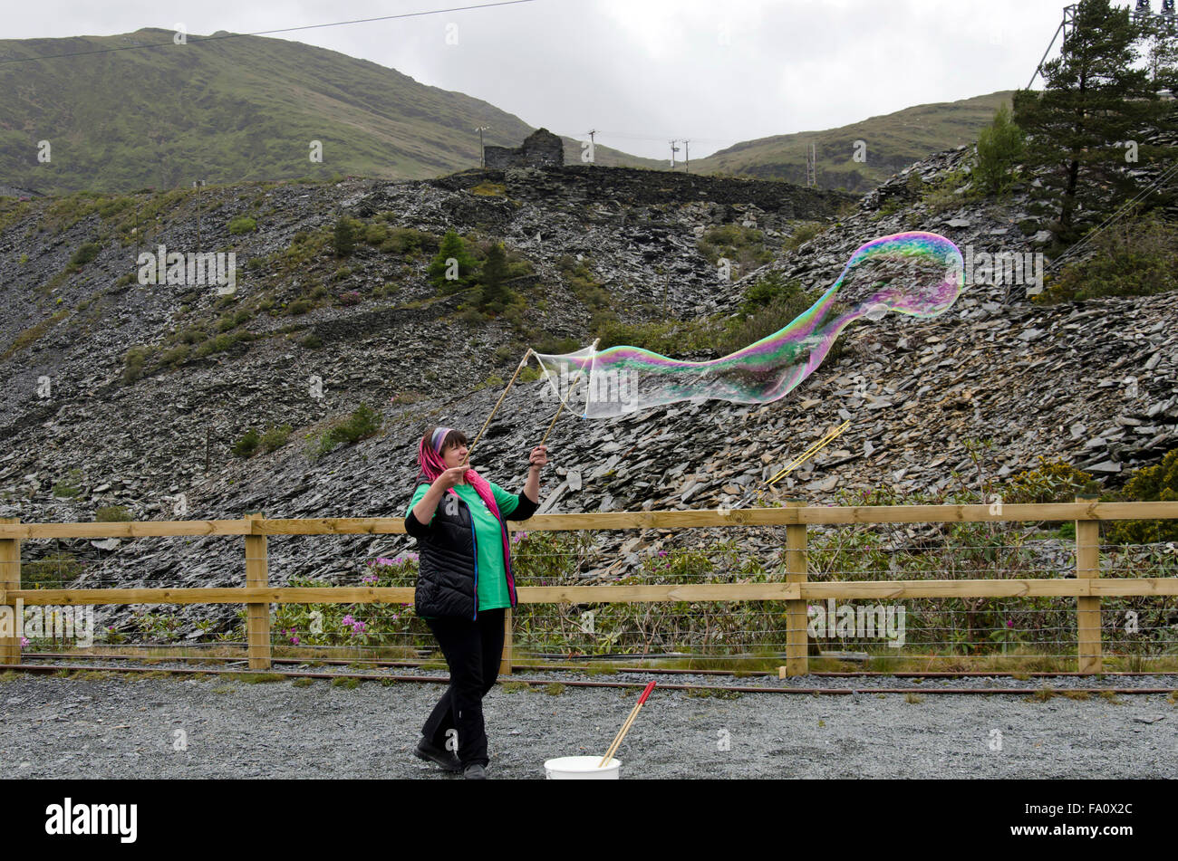 Woman blowing large bubbles near the Llechwedd Slate Mine visitor ...