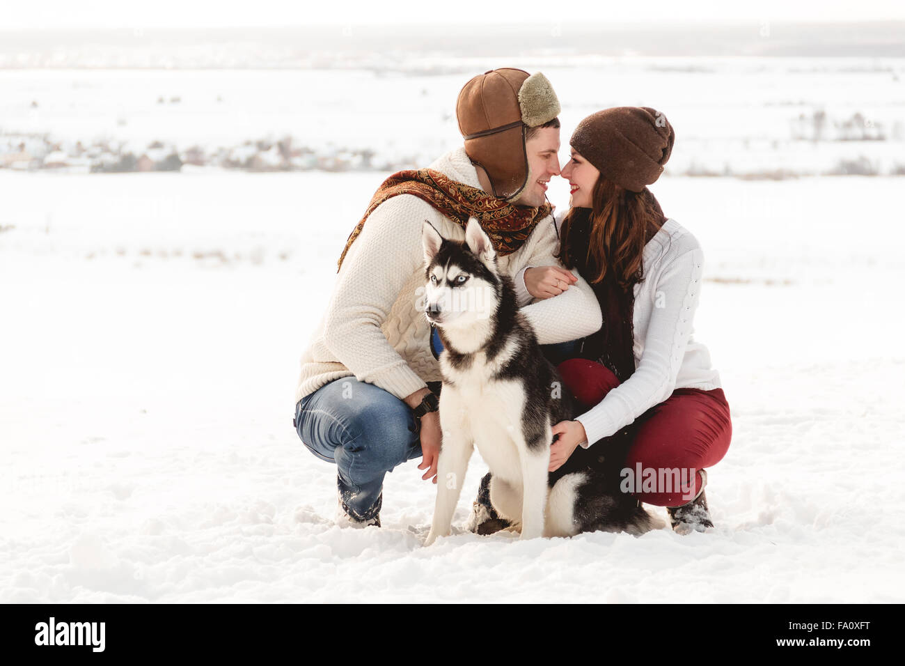 A beautiful girl and boy walking husky dog in winter forest Stock Photo ...