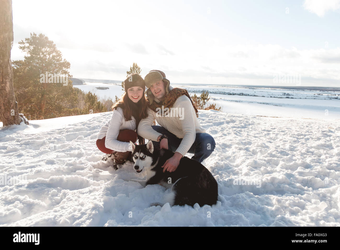 A beautiful girl and boy walking husky dog in winter forest Stock Photo ...
