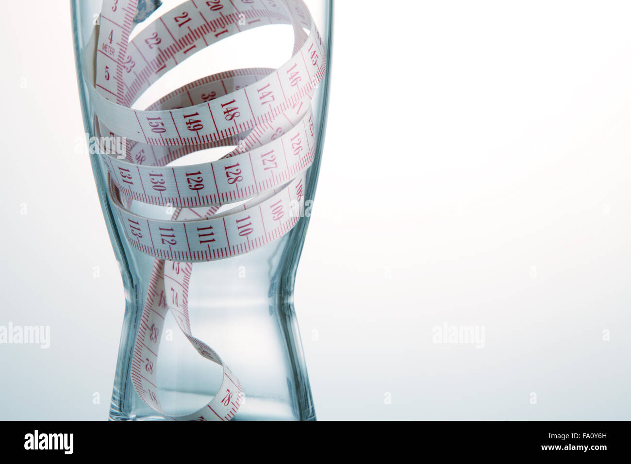 empty glass with tape measuring in it Stock Photo - Alamy
