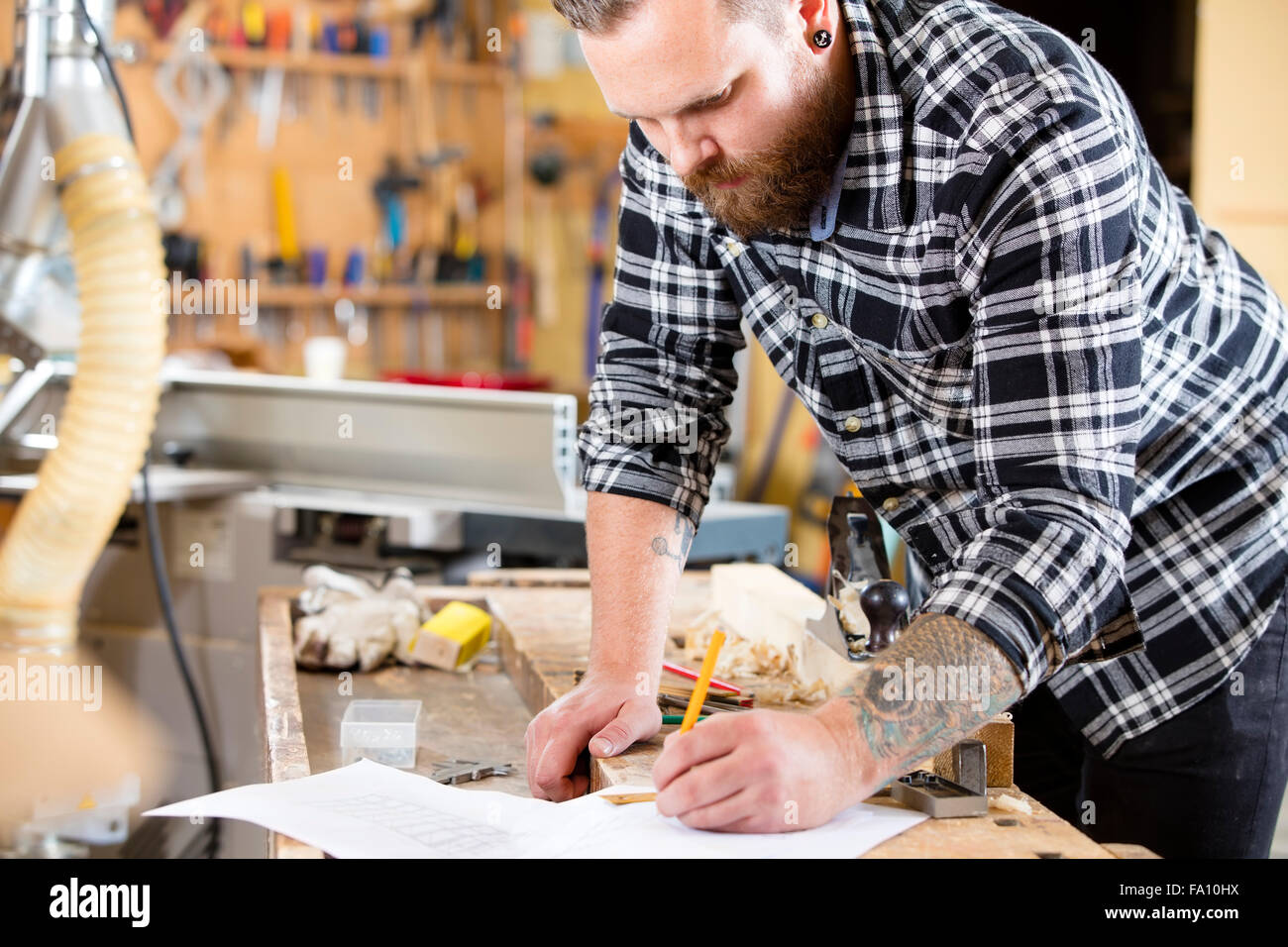 Carpenter plans work and take notes at project drawing Stock Photo - Alamy