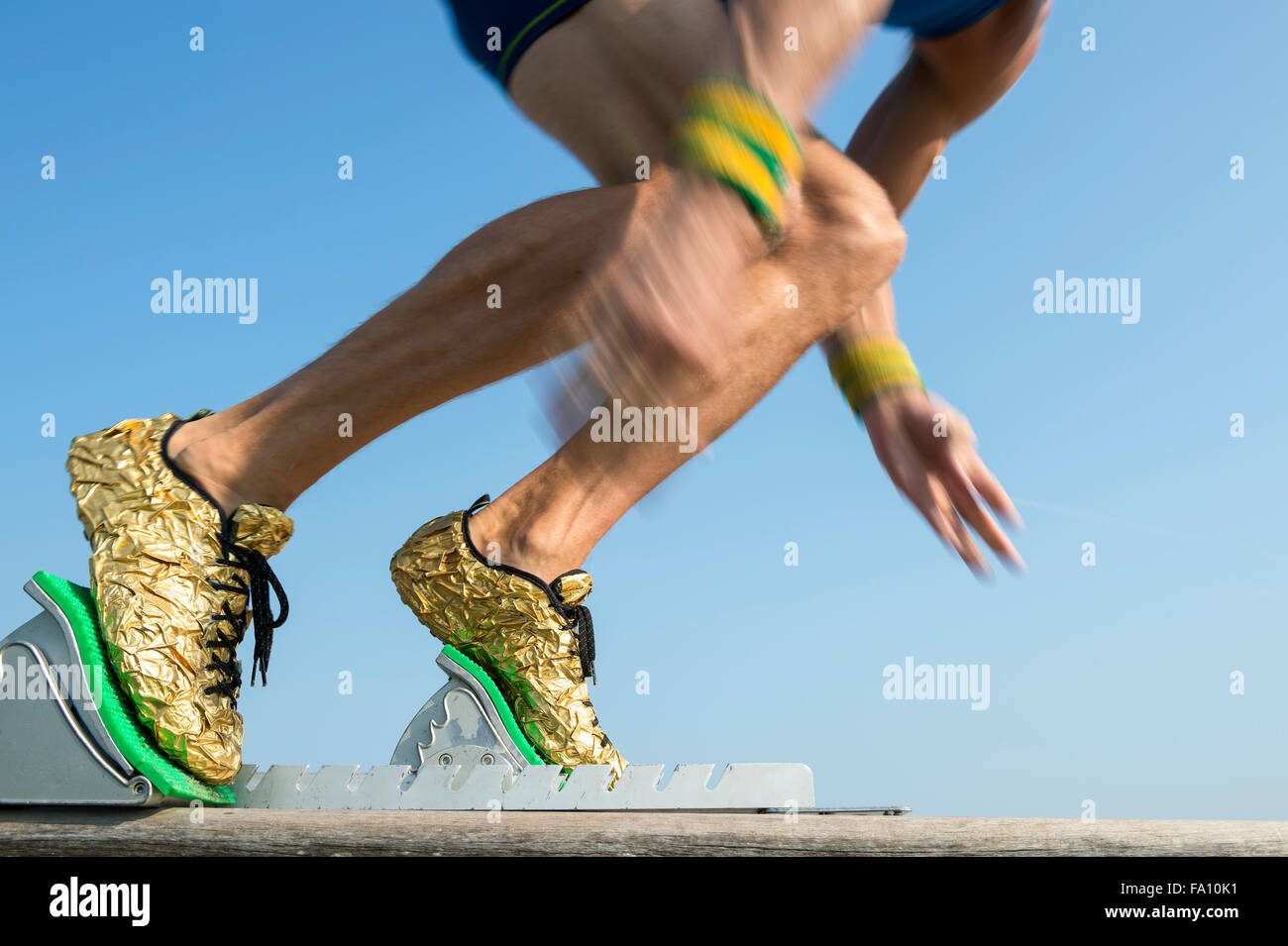 Athlete wearing gold running shoes takes off in a blur from from the ...