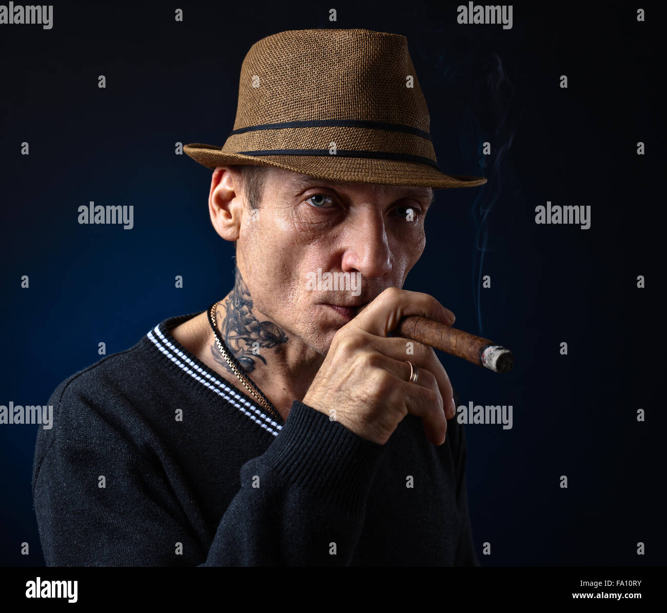 man with hat smoking cigar, studio shot Stock Photo - Alamy