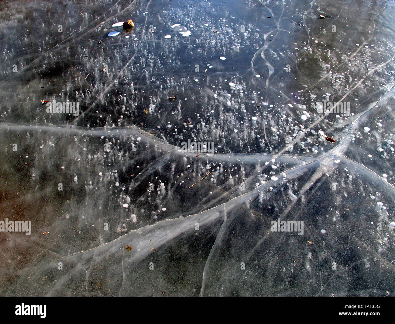 Frozen lake with cracking ice Stock Photo - Alamy