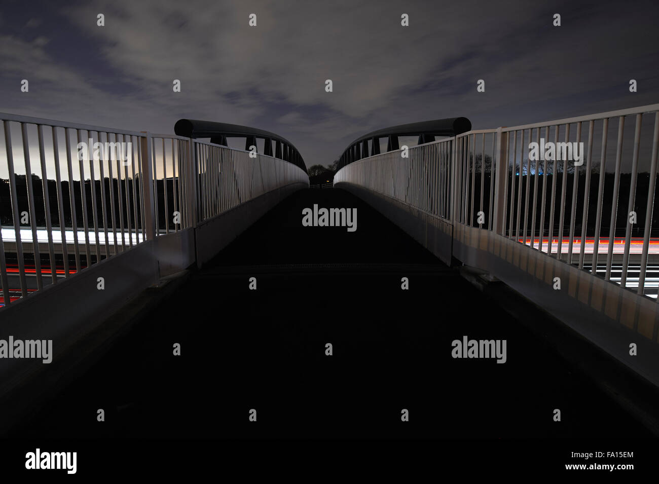 Foot-bridge over A46 road with light trails from passing vehicles below ...