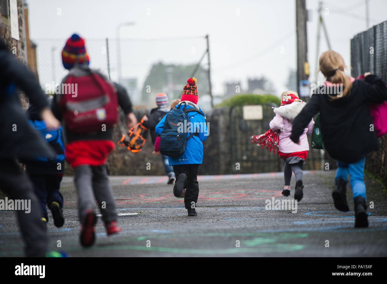 A group of primary school children dashing rushing running out of their ...