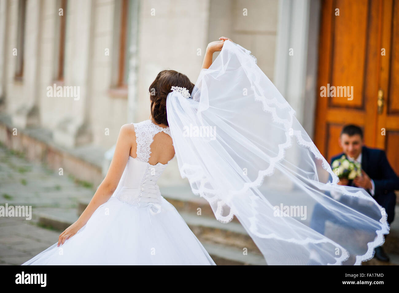 Bride play with veil background her groom Stock Photo - Alamy