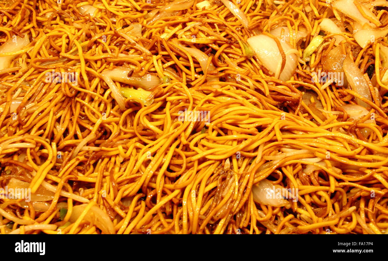 Fried noodles and onions for sale on a takeaway food stall at an ...