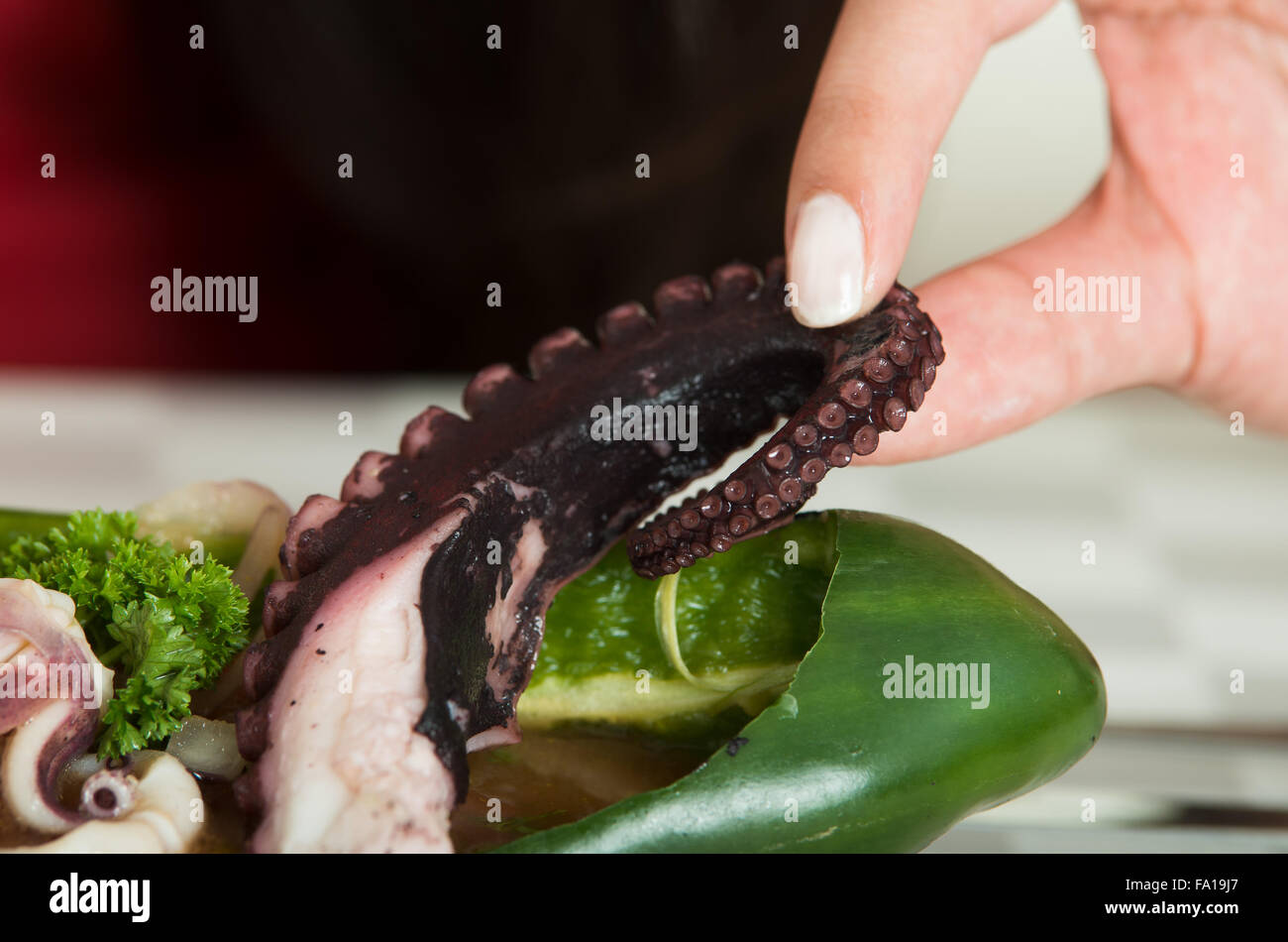 Close up shot of young woman eating octopus Stock Photo - Alamy