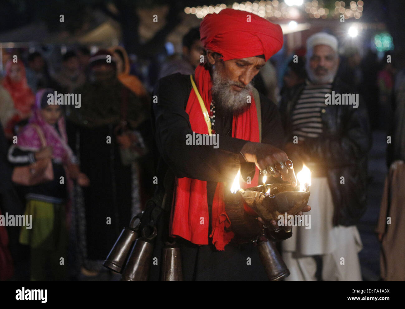 Lahore, Pakistan. 19th Dec, 2015. Pakistani Muslim devotee lights ...
