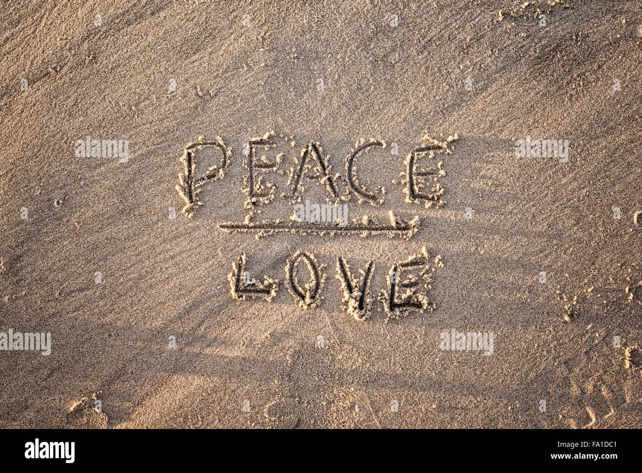 The words peace and love written in sand Stock Photo - Alamy