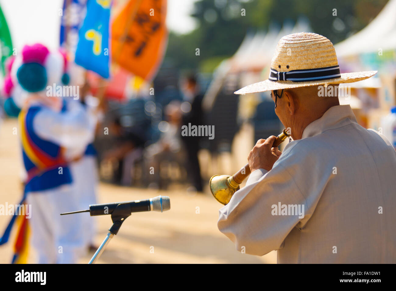 Korean senior man playing a traditional wind instrument, taepyeongso ...