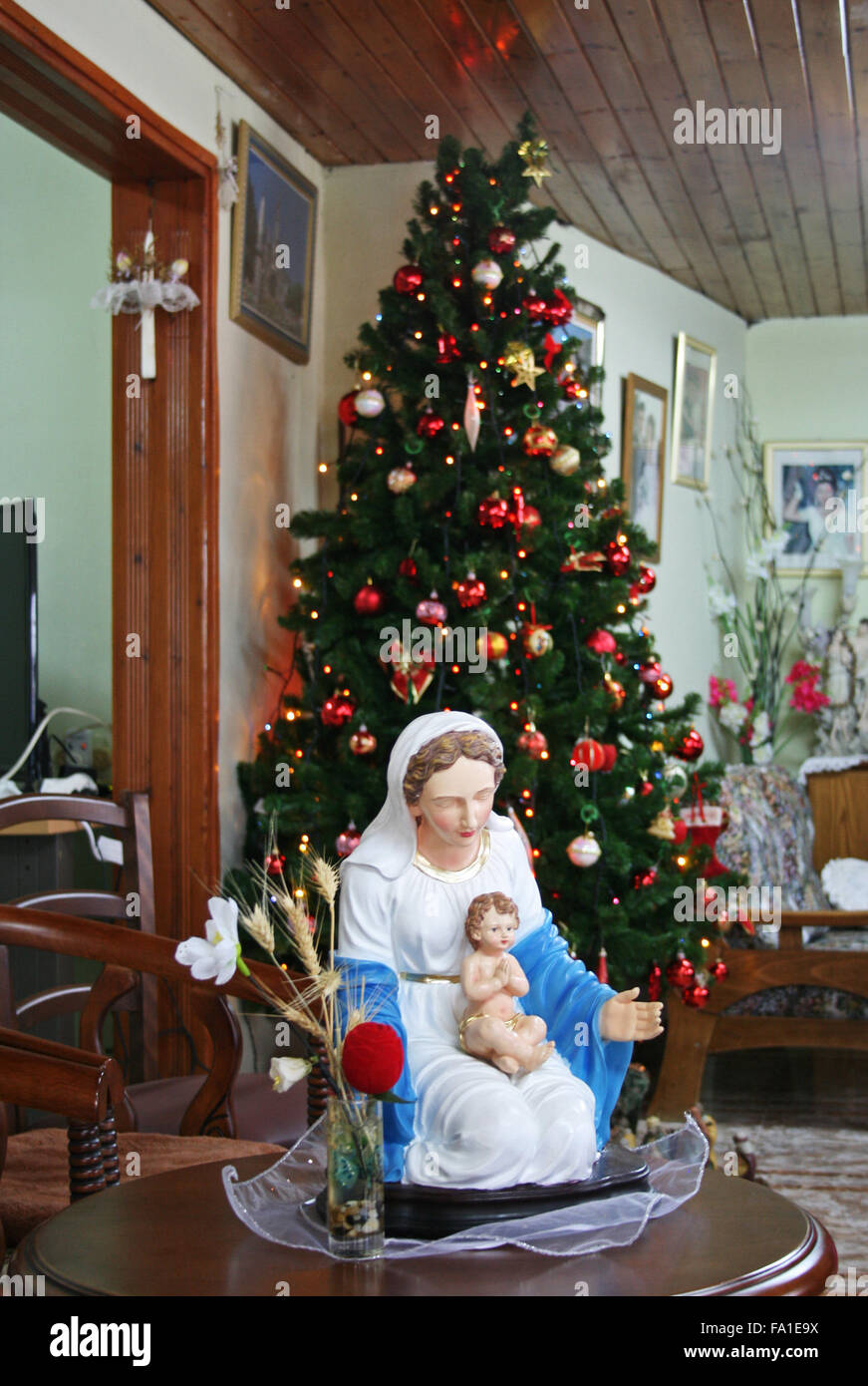 A statue of Madonna in front of a Christmas tree in the home of the ...