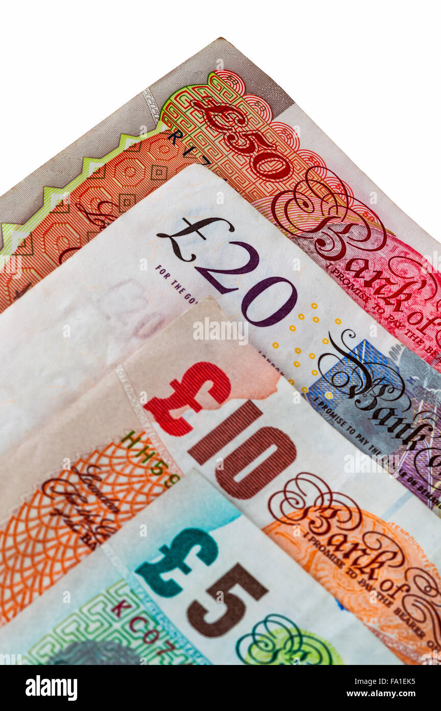 Four paper UK currency notes white background clipping path closeup ...