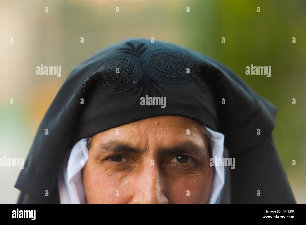 Half face portrait of Kashmiri muslim woman wearing pulled back black ...