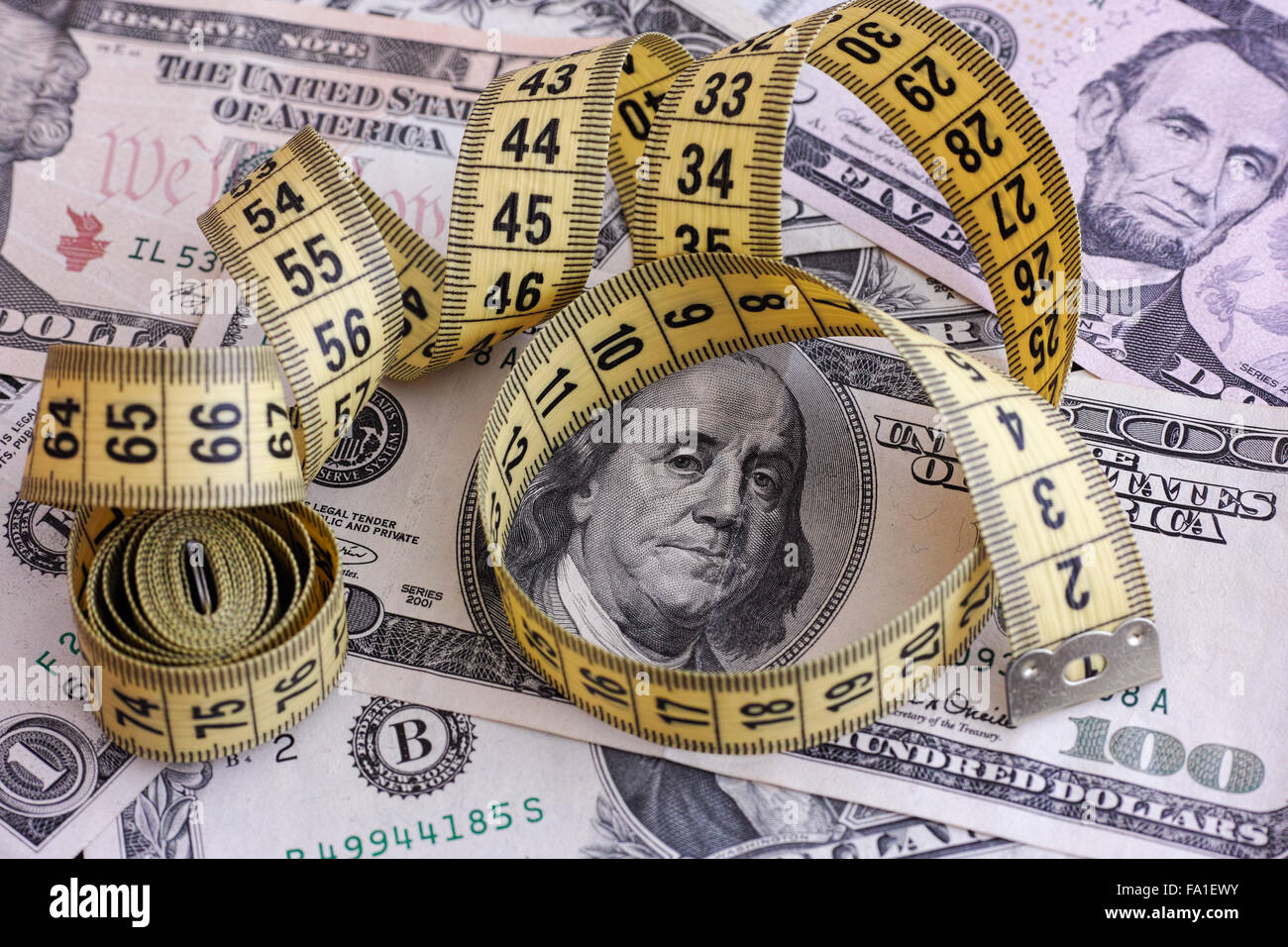 Dollar banknotes and yellow tape measure. Close up Stock Photo - Alamy