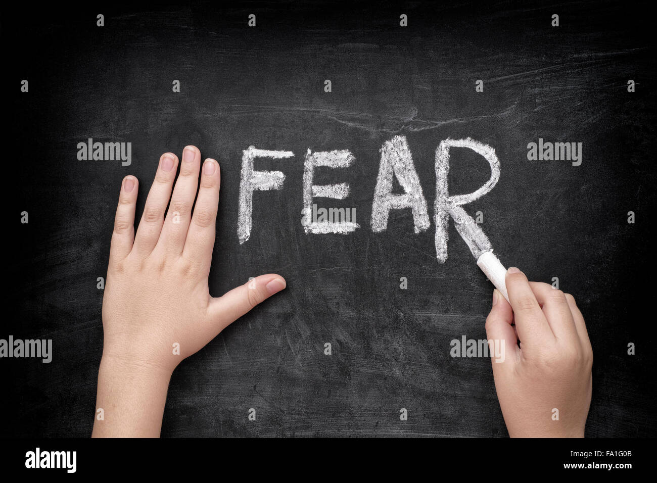 Child writing word Fear on a blackboard Stock Photo - Alamy
