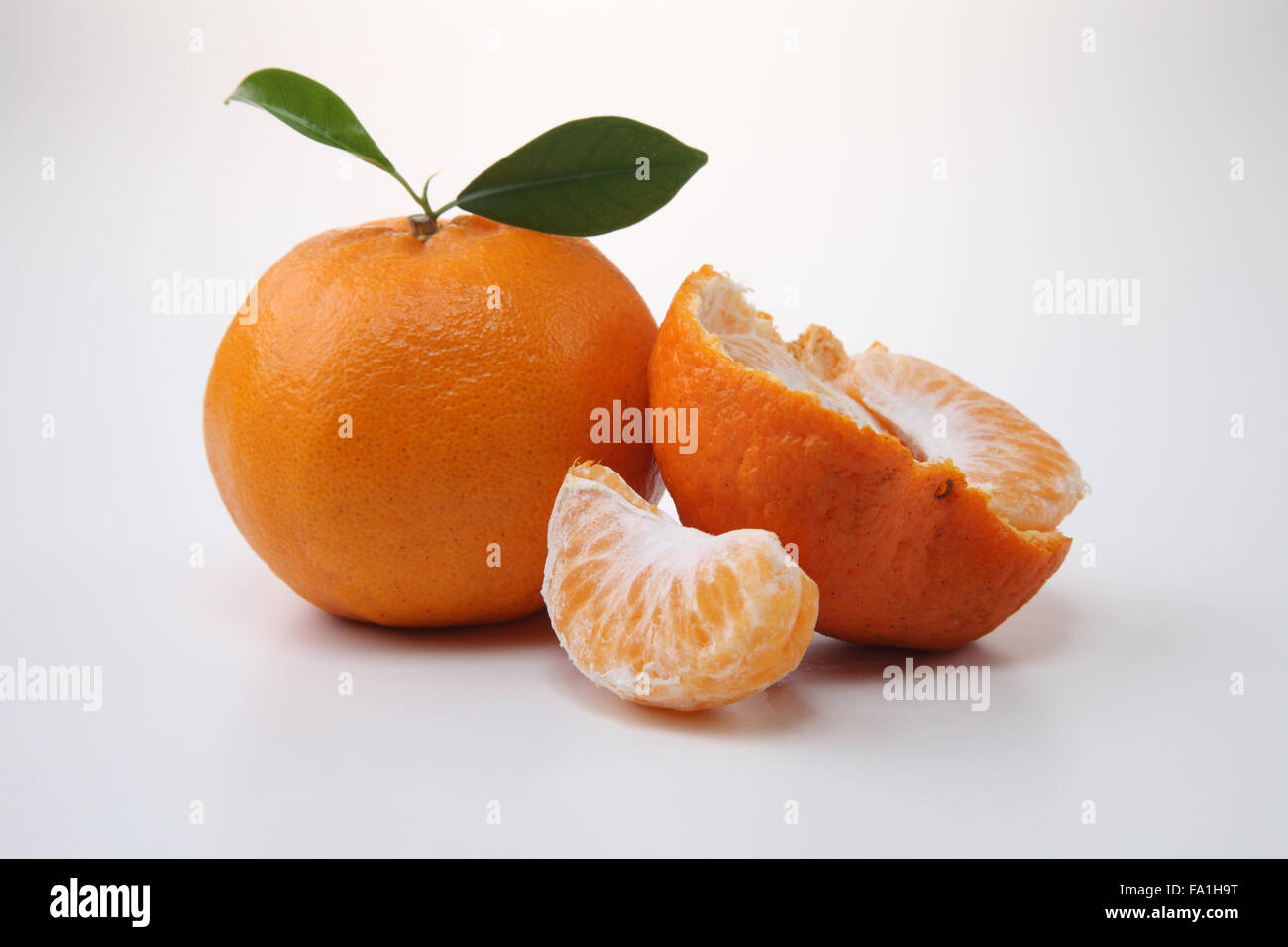 One mandarin orange and one half open Stock Photo - Alamy
