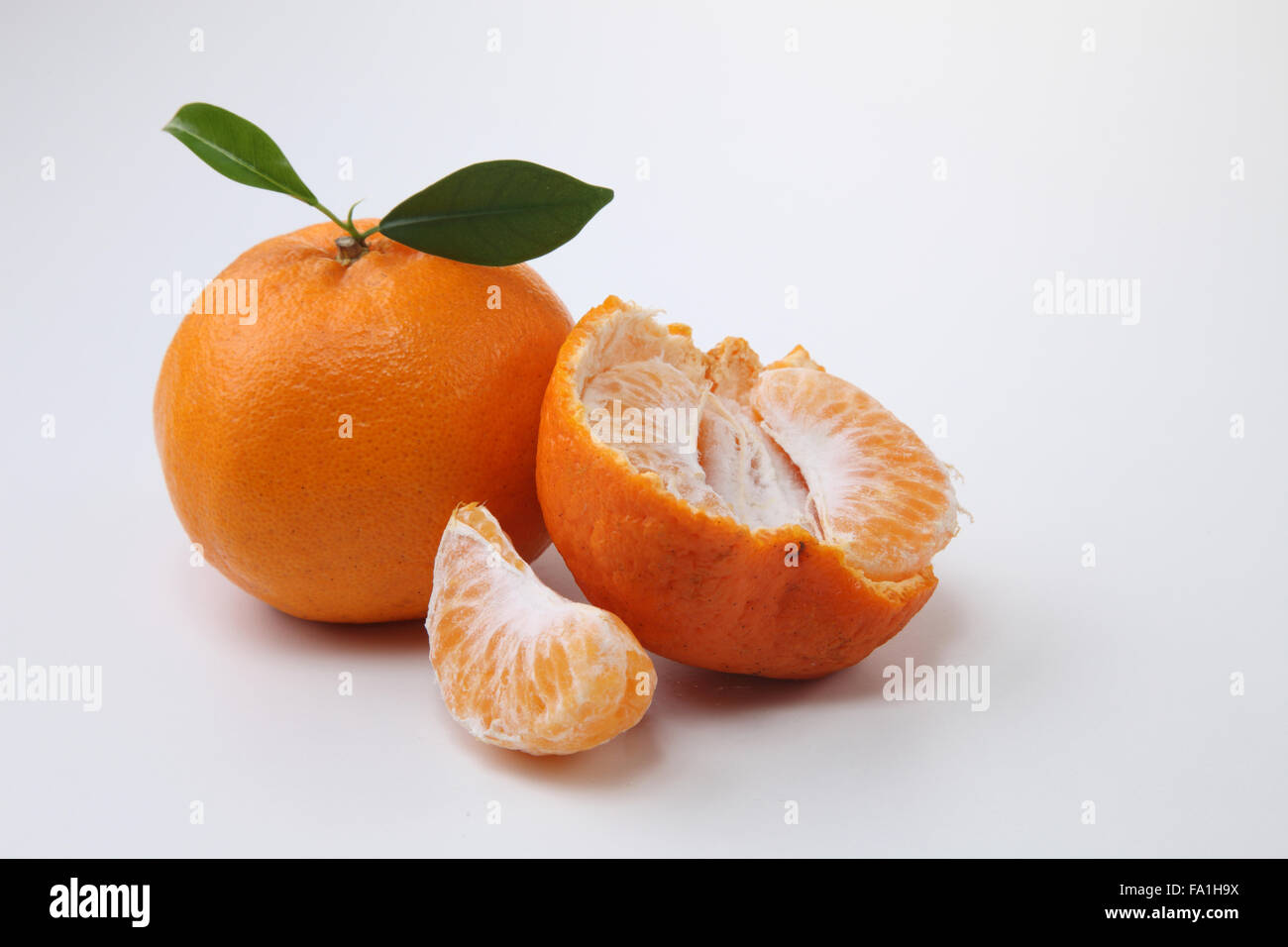 One mandarin orange and one half open Stock Photo - Alamy