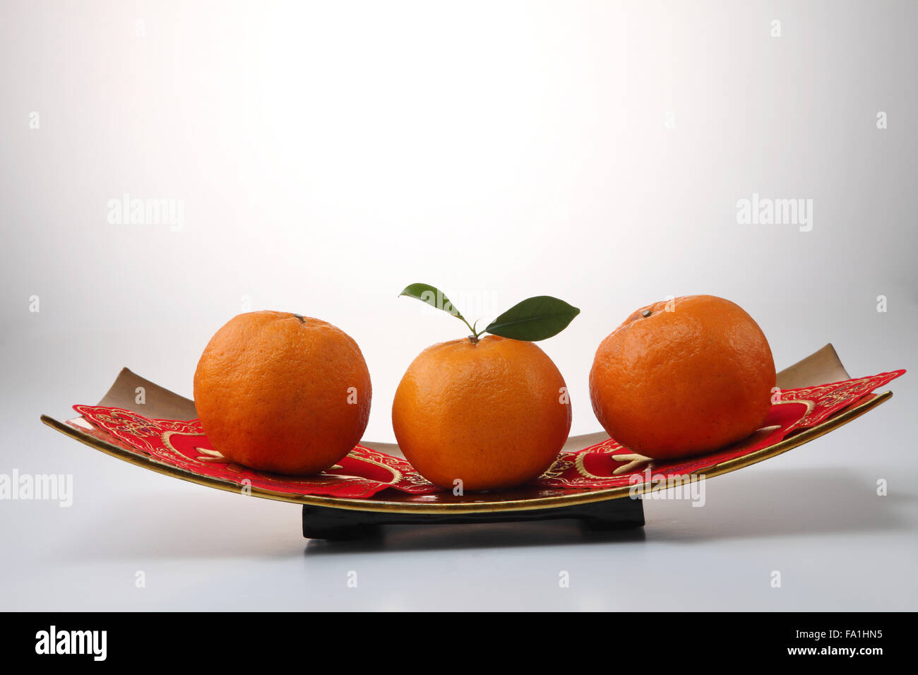 three oranges on the golden plate Stock Photo - Alamy