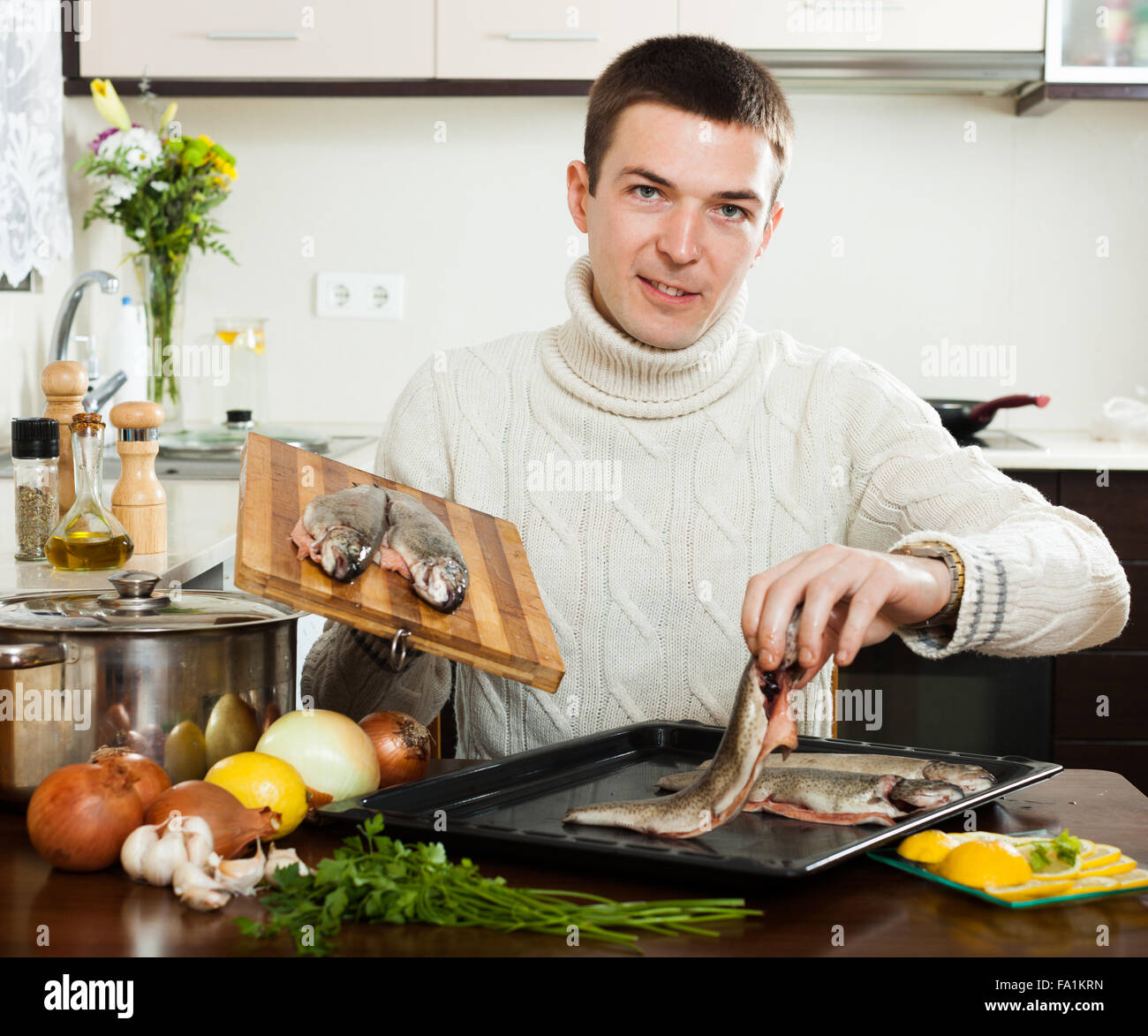 guy cooking trout fish with lemon in frying pan Stock Photo - Alamy