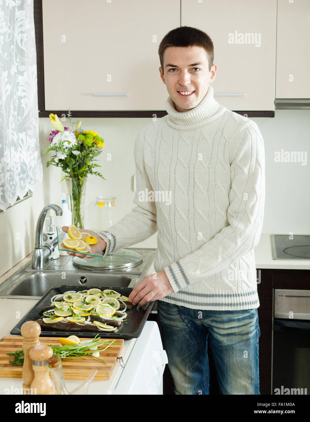 Handsome man with fish on roasting pan Stock Photo - Alamy
