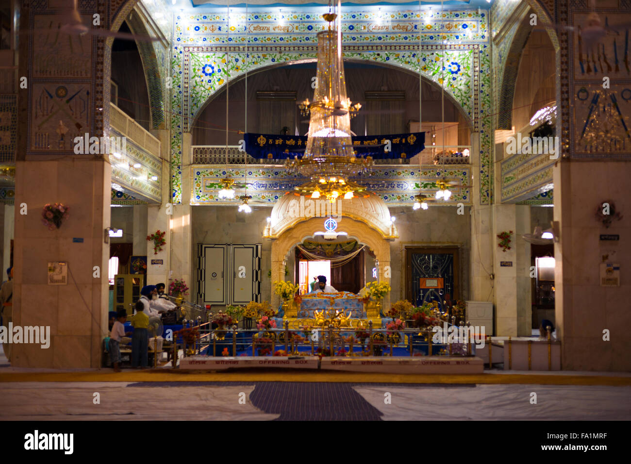 A Sikh religious service is held at an altar and raised platform inside ...