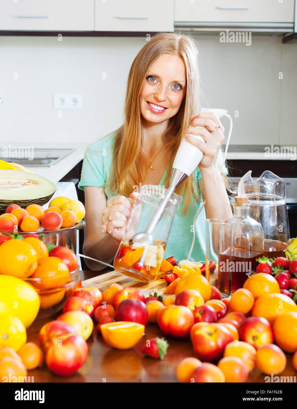 Happy girl making fruits cocktail with blender at home kitchen Stock ...