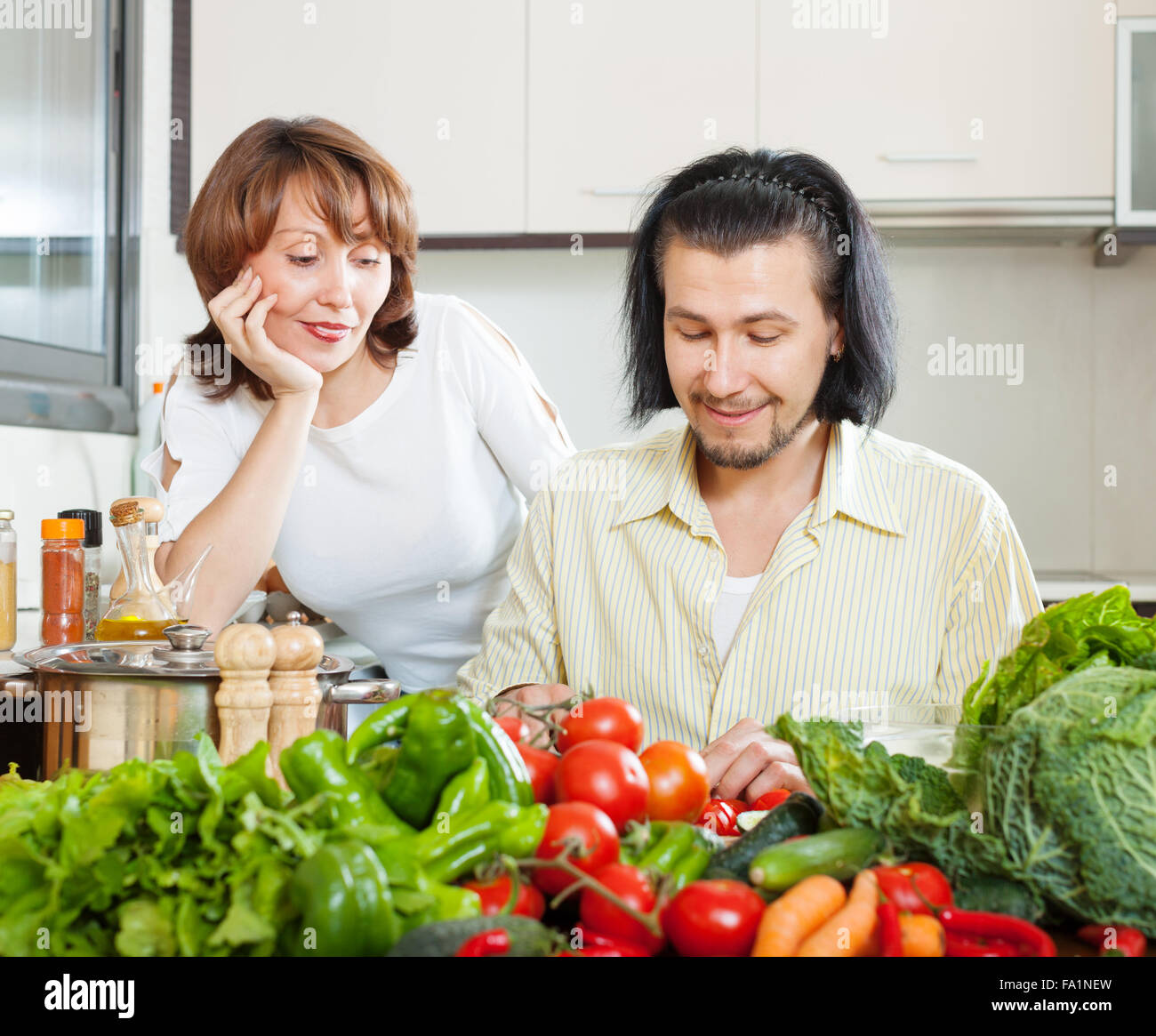Flirting couple cooking together in kitchen Stock Photo - Alamy