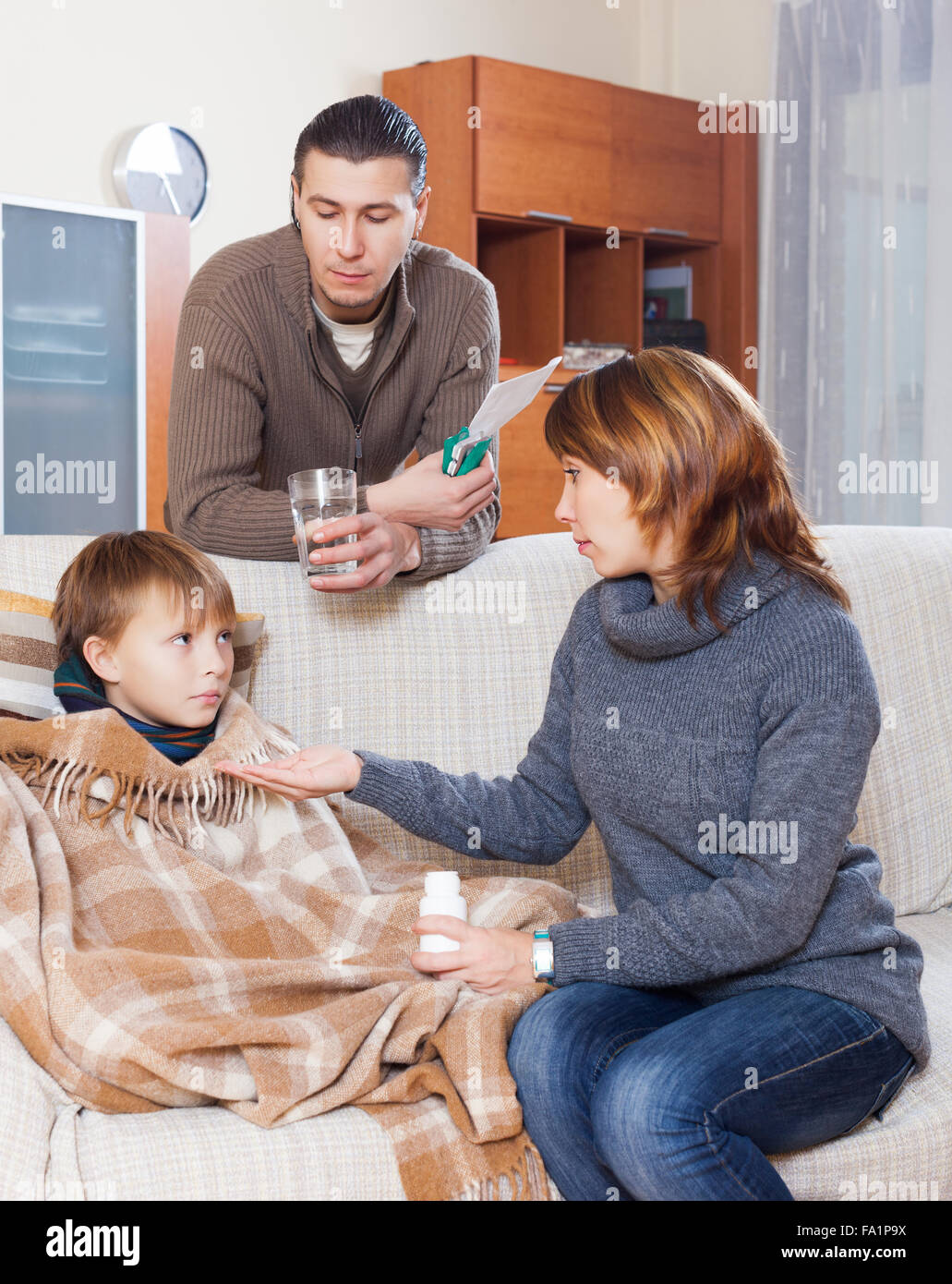 Parents caring for sick son in home Stock Photo - Alamy