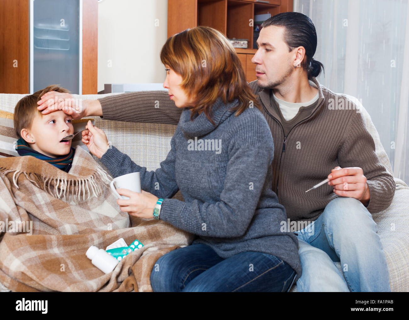 Caring parents and son with thermometer at home Stock Photo - Alamy