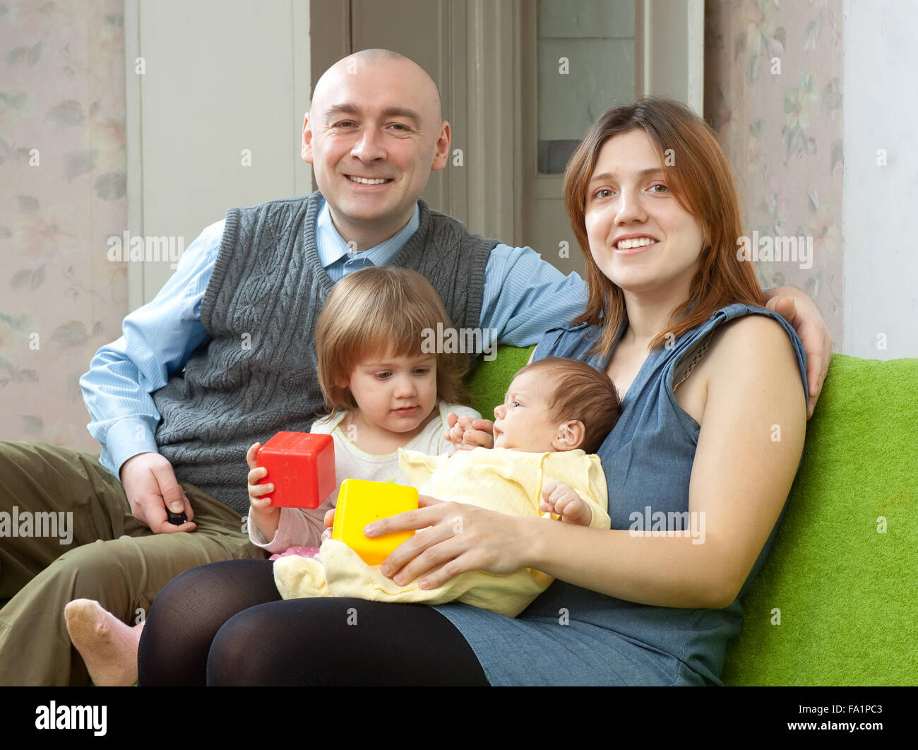 Happy parents with their two baby at home Stock Photo - Alamy
