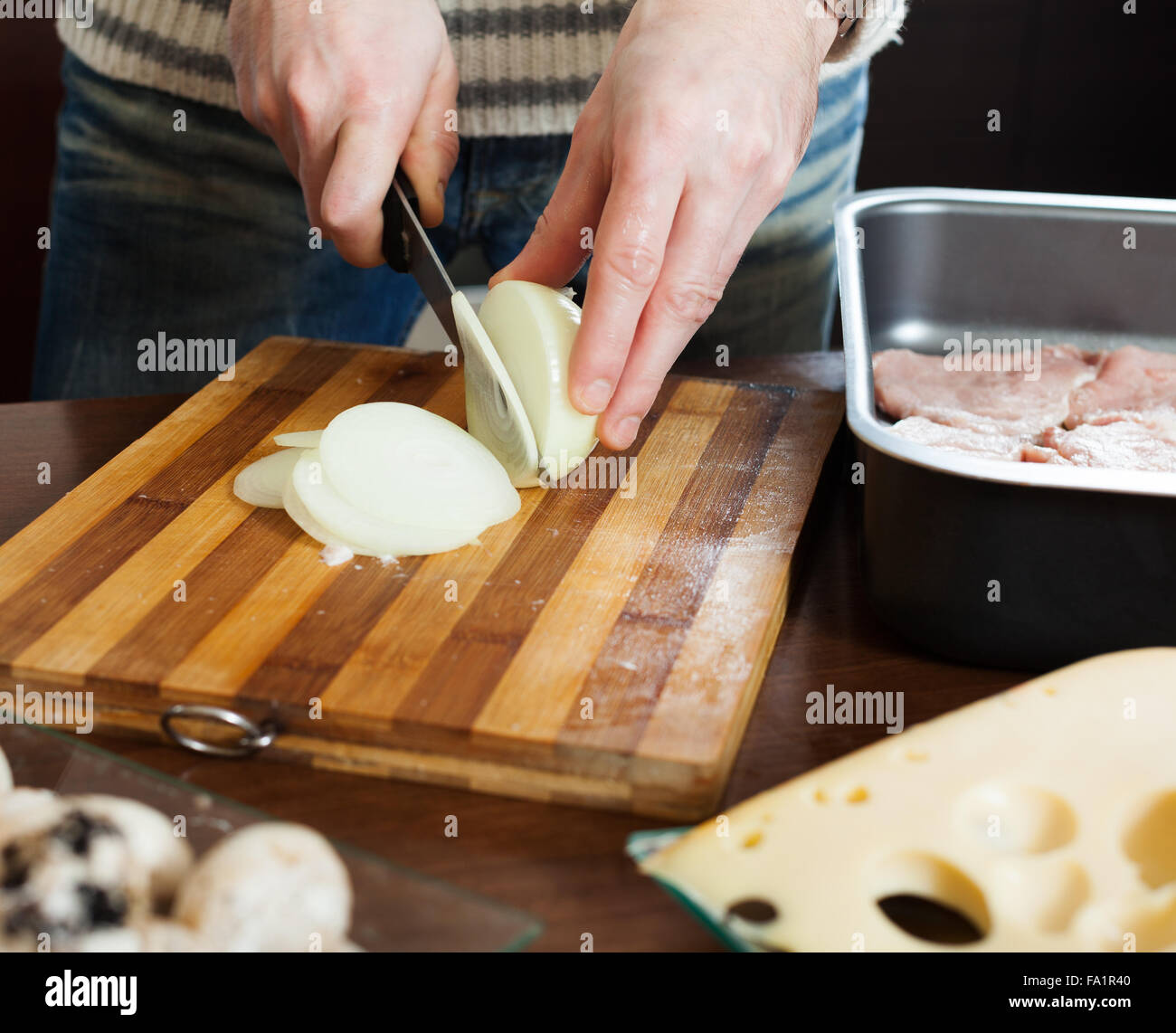 Steps of cooking french-style meat in roasting pan. Hands cutting onion ...