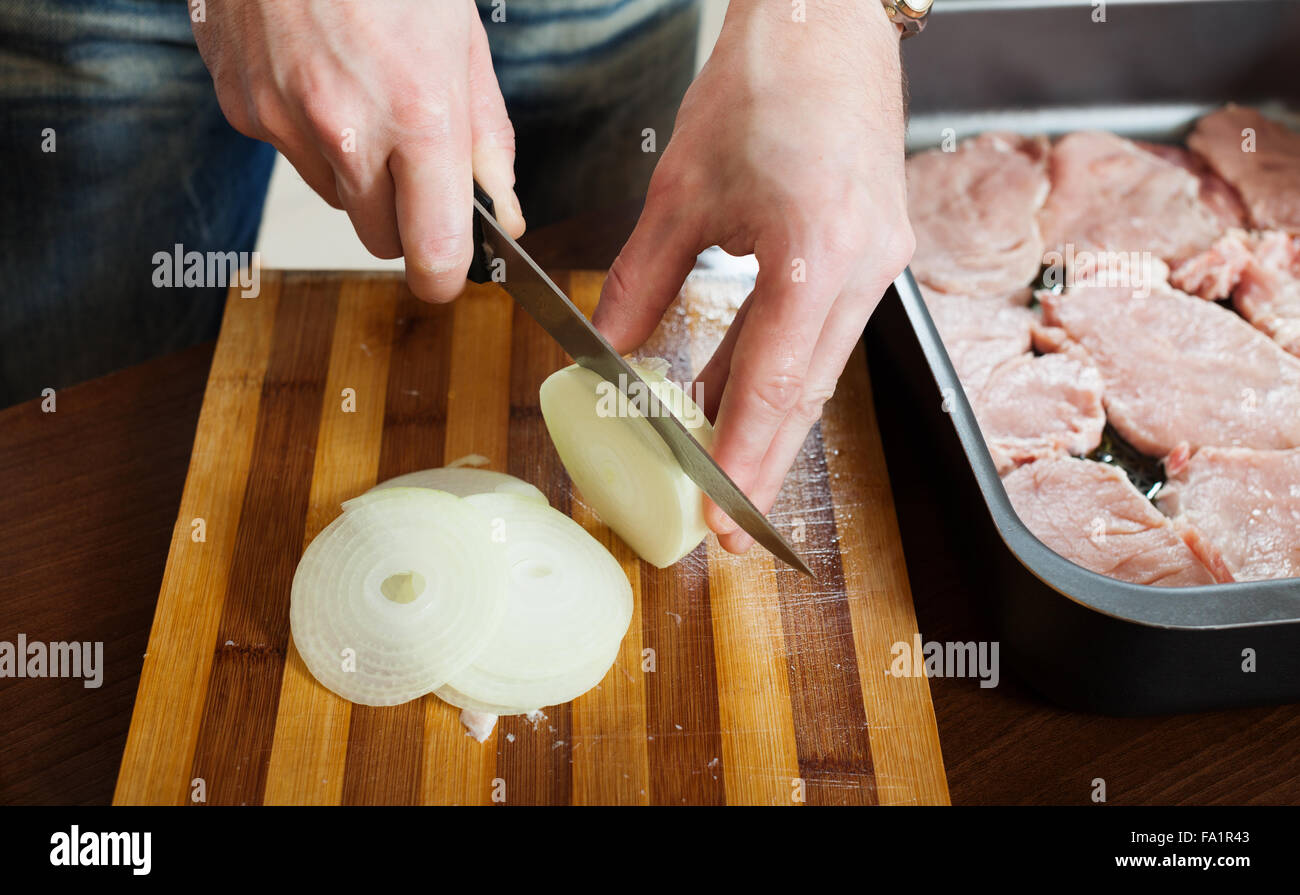 Steps of cooking meat in roasting pan. Hands cutting onion Stock Photo ...