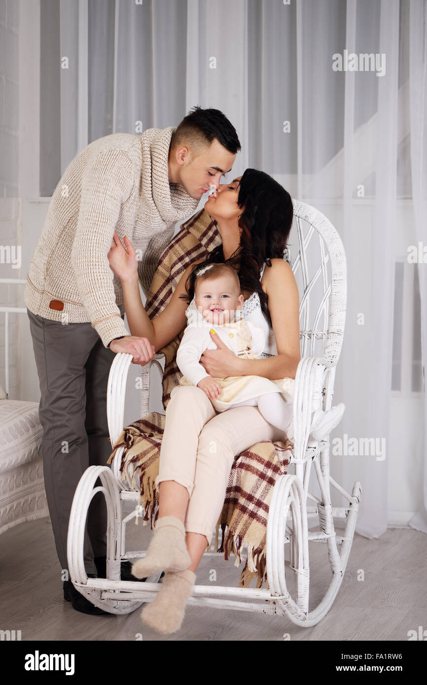 parents with a child on a chair Stock Photo - Alamy