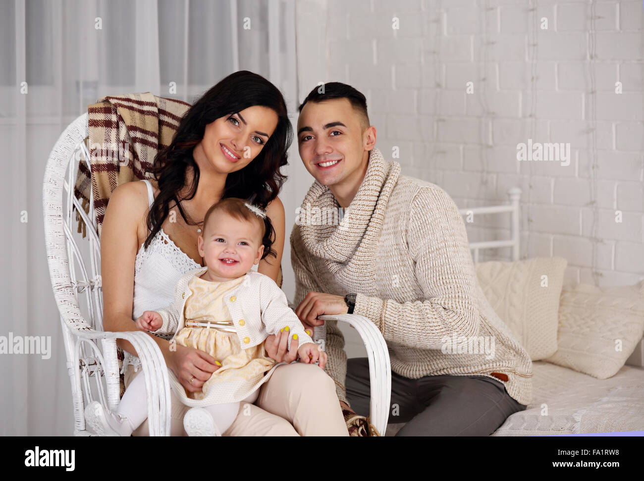 parents with a child on a chair Stock Photo - Alamy