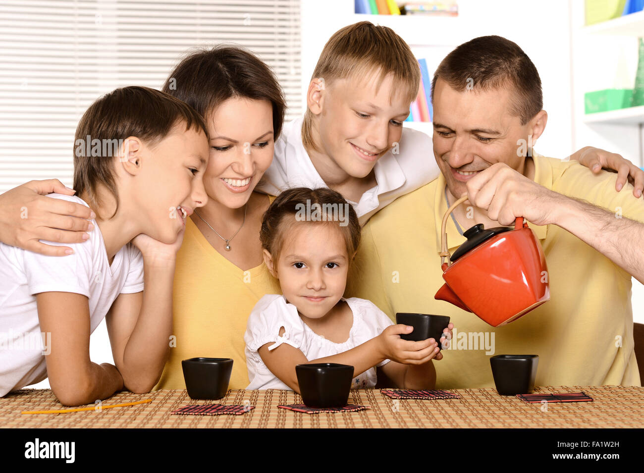 Family drinking tea at table Stock Photo - Alamy