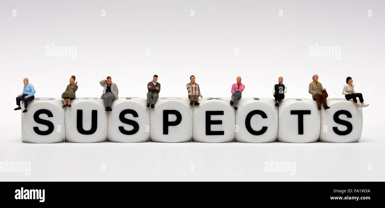 A line up of miniature people suspects sitting on the word suspects ...
