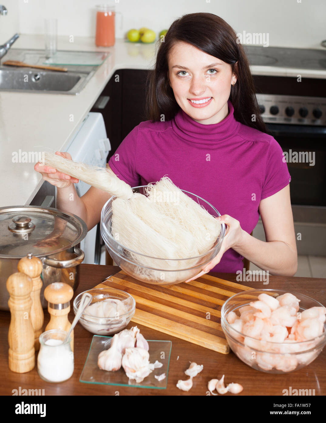 woman with ingredients for cooking noodles with seafood in home Stock ...