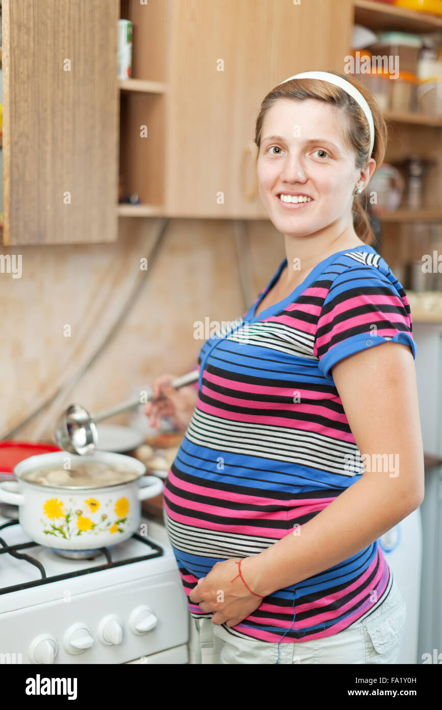 pregnant woman cooking food in her kitchen Stock Photo - Alamy