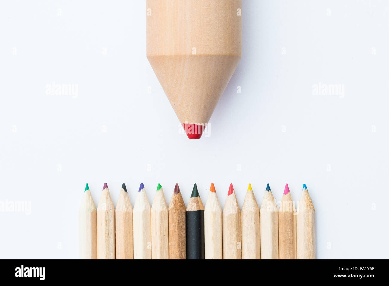 small pile of crayons and one huge crayon Stock Photo - Alamy