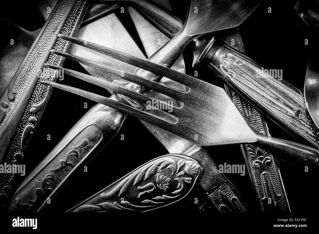 Abstract black and white photo of mixed silver forks, spoons and knives ...