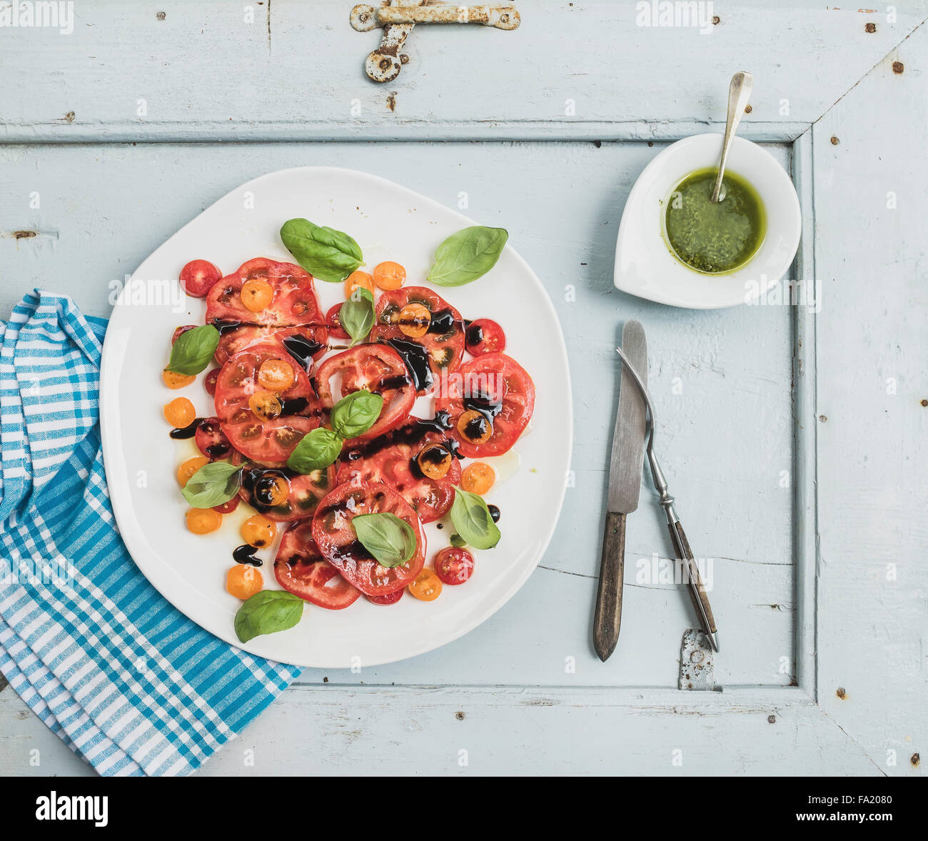 Ripe village heirloom tomato salad with olive oil and basil over light ...