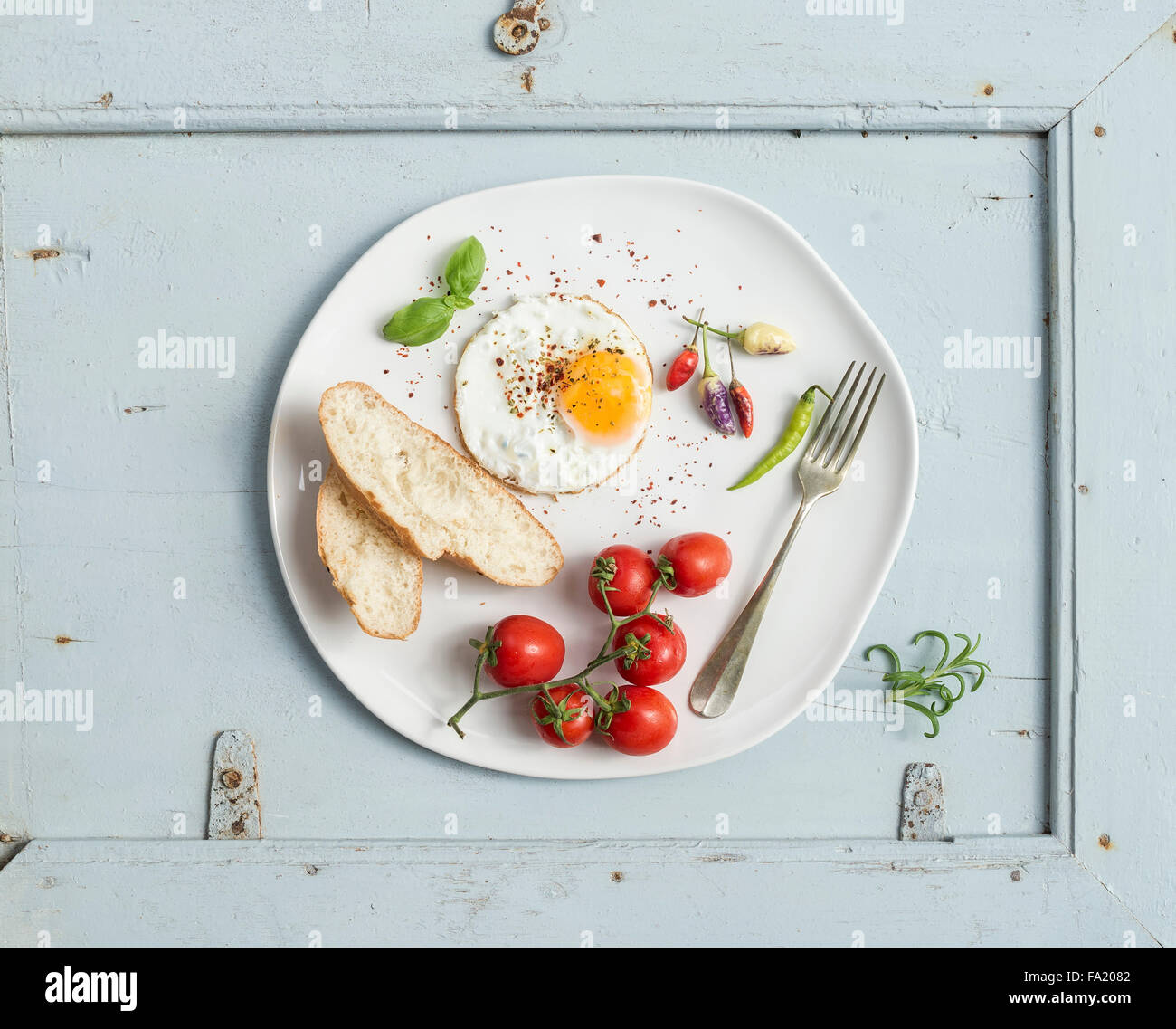 Breakfast set. Fried egg, bread slices, cherry tomatoes, hot peppers ...