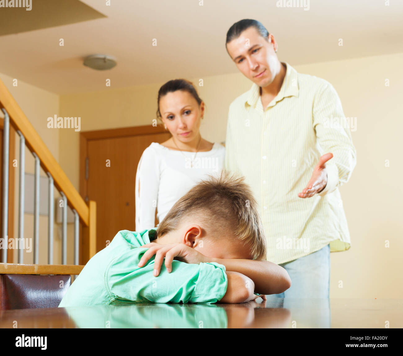 Parents berating teenager son in home. Focus on boy Stock Photo - Alamy