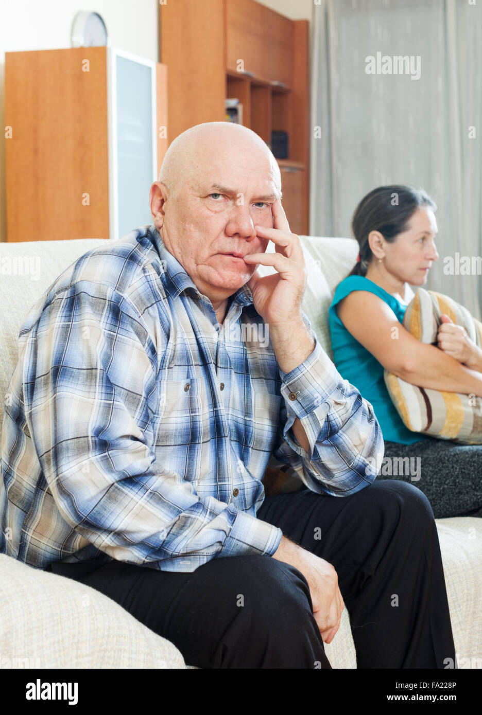 Family quarrel. Upset senior man against sad wife at home Stock Photo ...