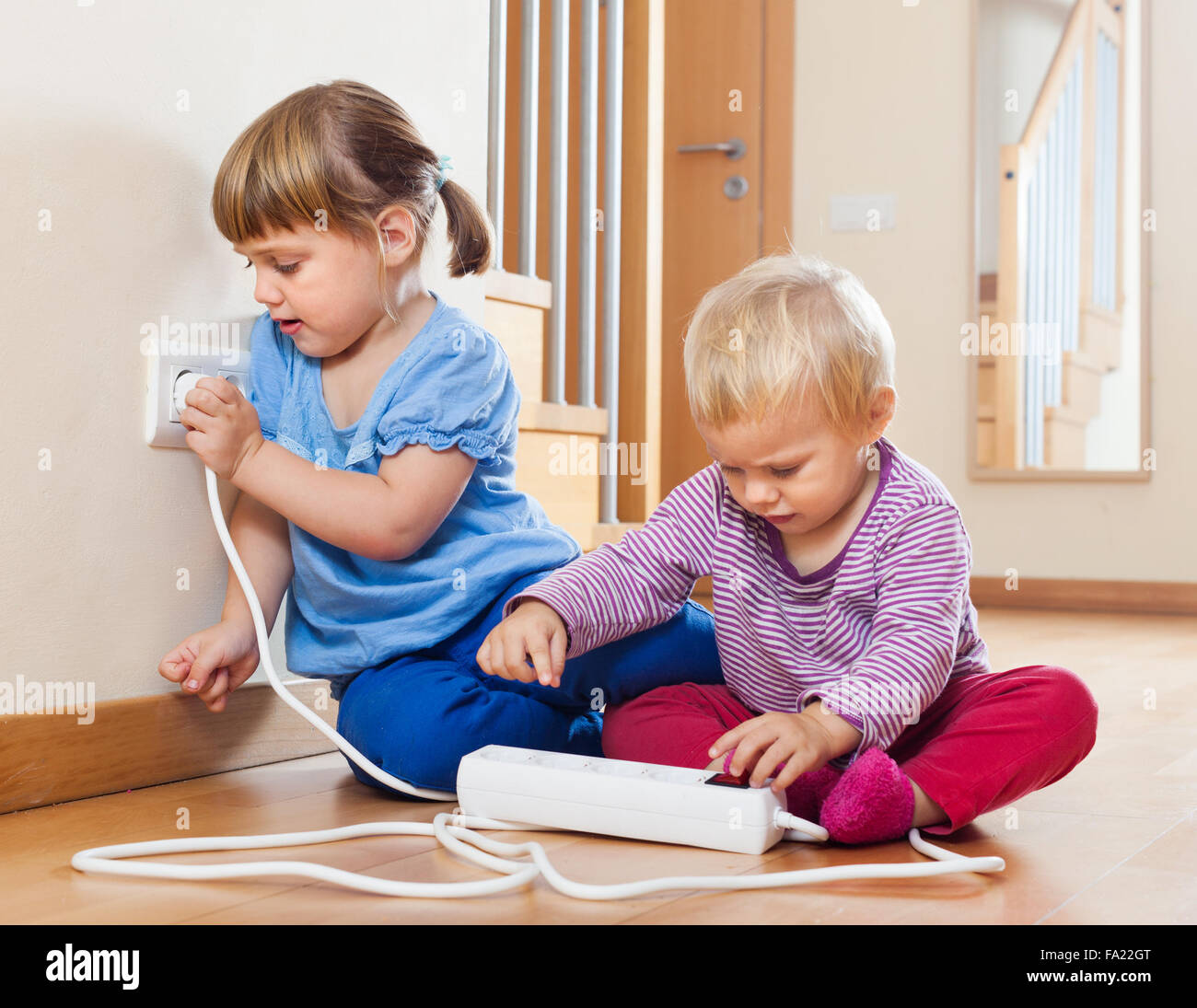 Two children playing with electricity on floor at home Stock Photo - Alamy